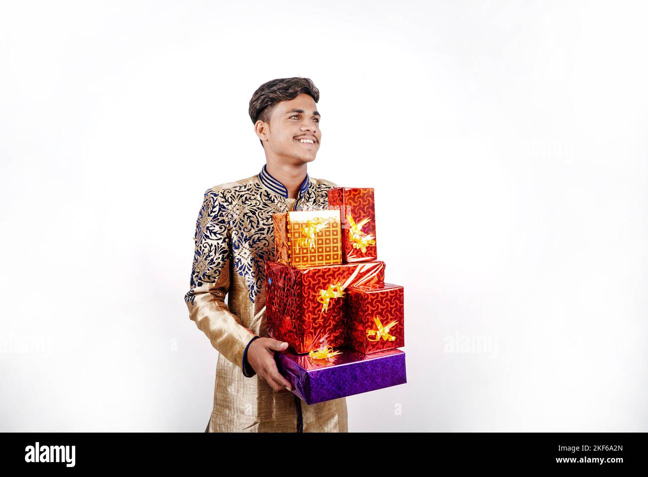 Indian man in ethnic wear and Holding gift box in hand , isolated over ...