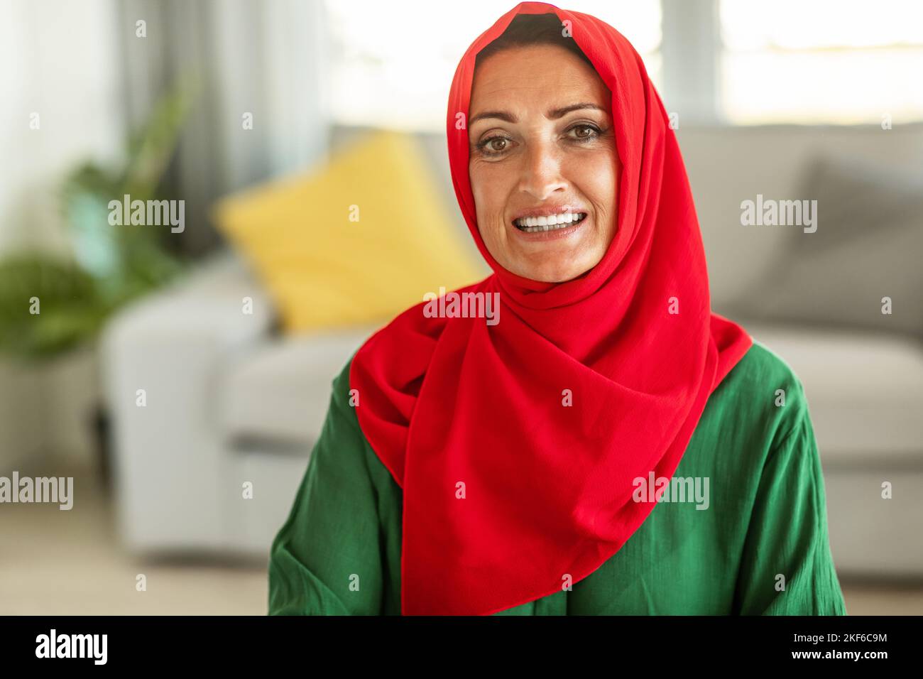 Portrait of positive mature muslim woman wearing hijab and smiling at ... Portrait of positive mature muslim woman wearing hijab and smiling at ...