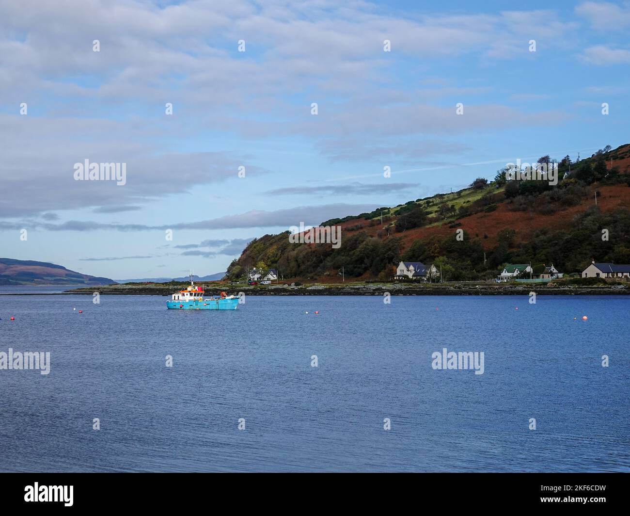 Working boat in harbour and cottages along the shore of Loch Ranza, a ...