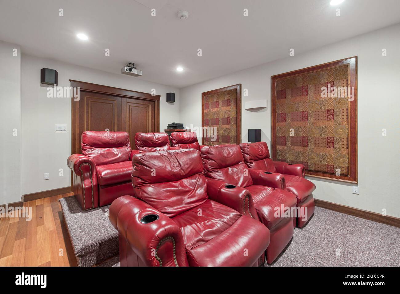 A cozy cinema room with red couches in a mansion Stock Photo - Alamy