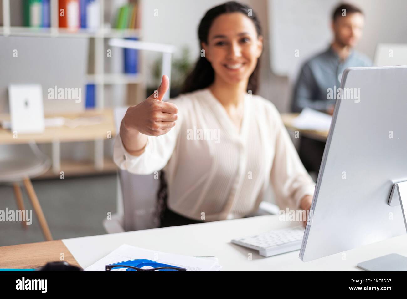 Happy millennial european woman manager working at computer, show thumb ...