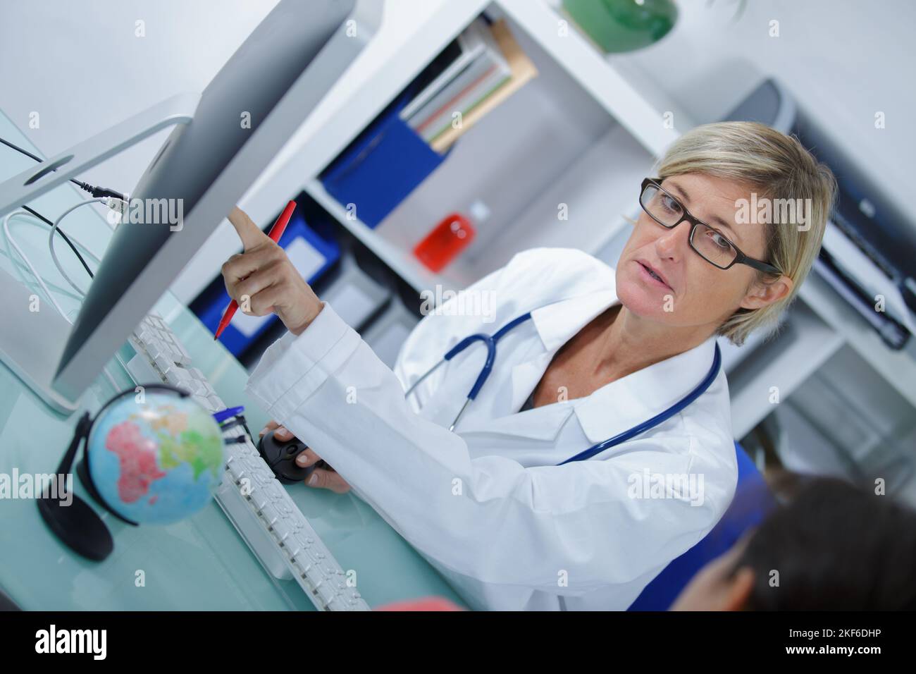 female doctor pointing to computer Stock Photo - Alamy