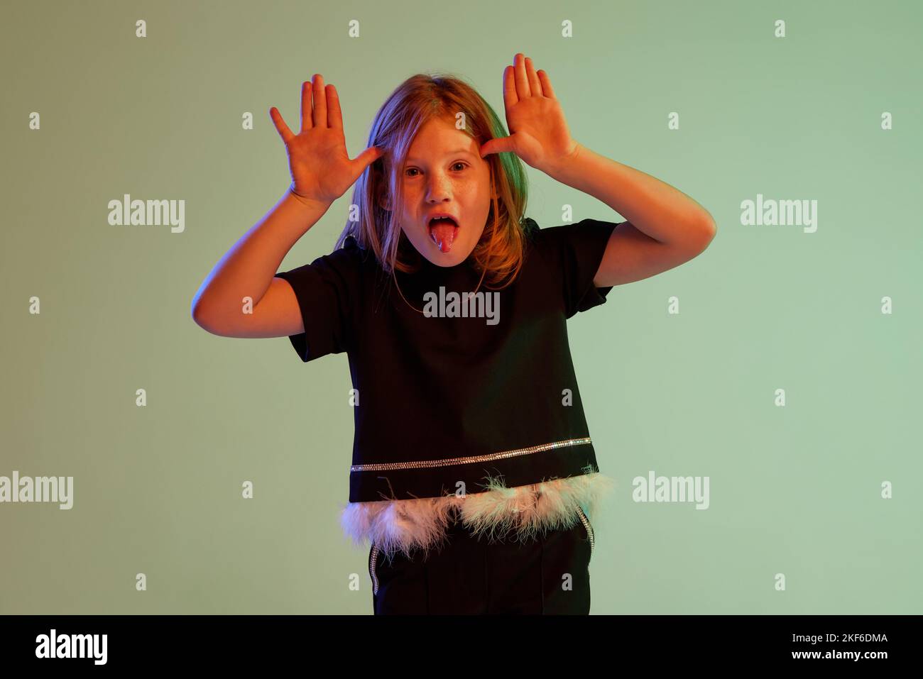 Grimace. Half-length portrait of charming emotional little girl ...