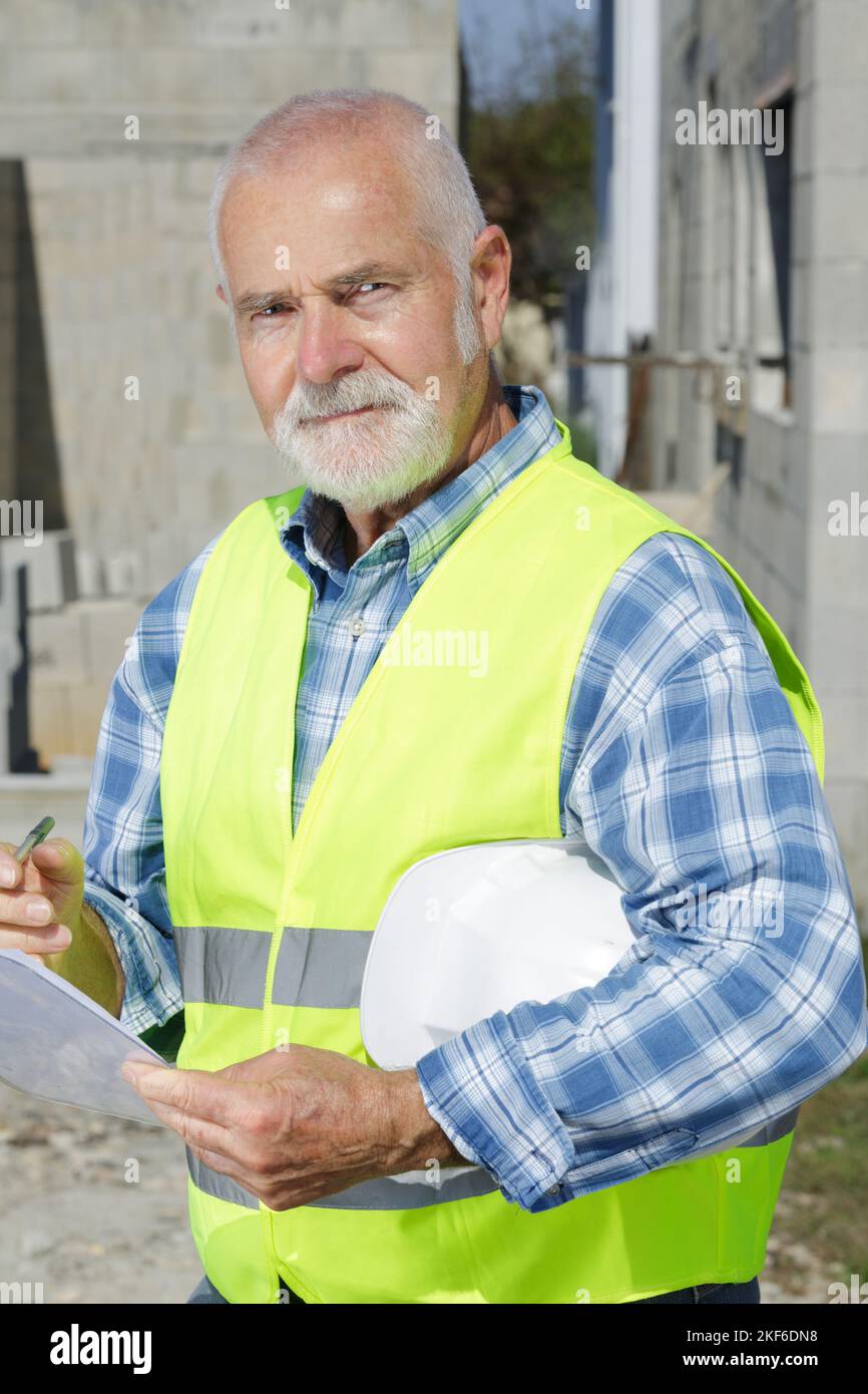 male senior builder writing something outdoors Stock Photo - Alamy