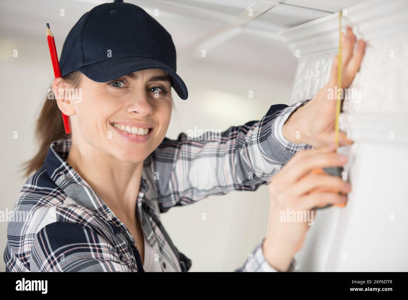 woman measuring dimensions on plasterboard panel Stock Photo - Alamy