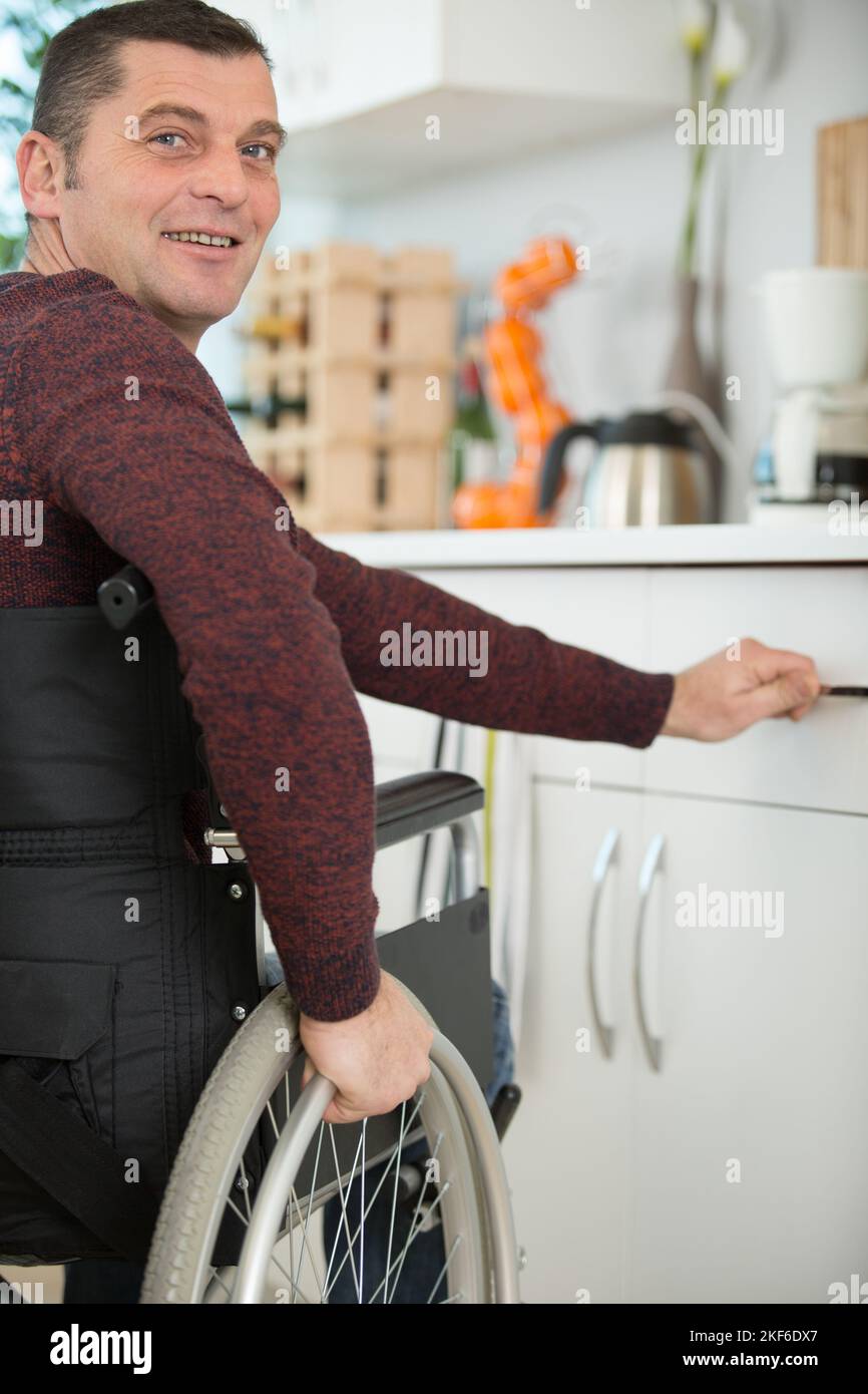 young disabled husband preparing food in kitchen Stock Photo - Alamy