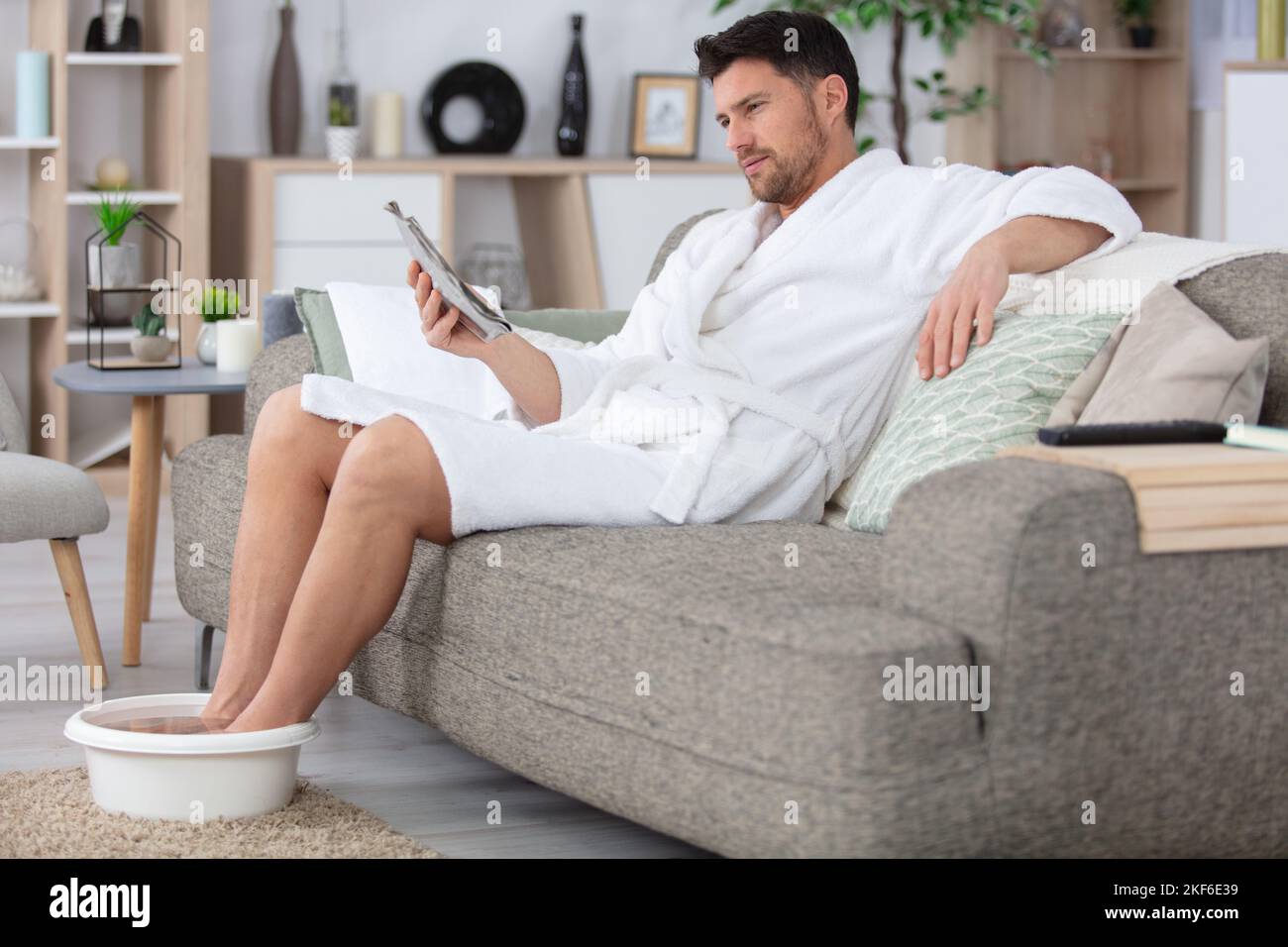 man on the sofa soaking his feet Stock Photo - Alamy