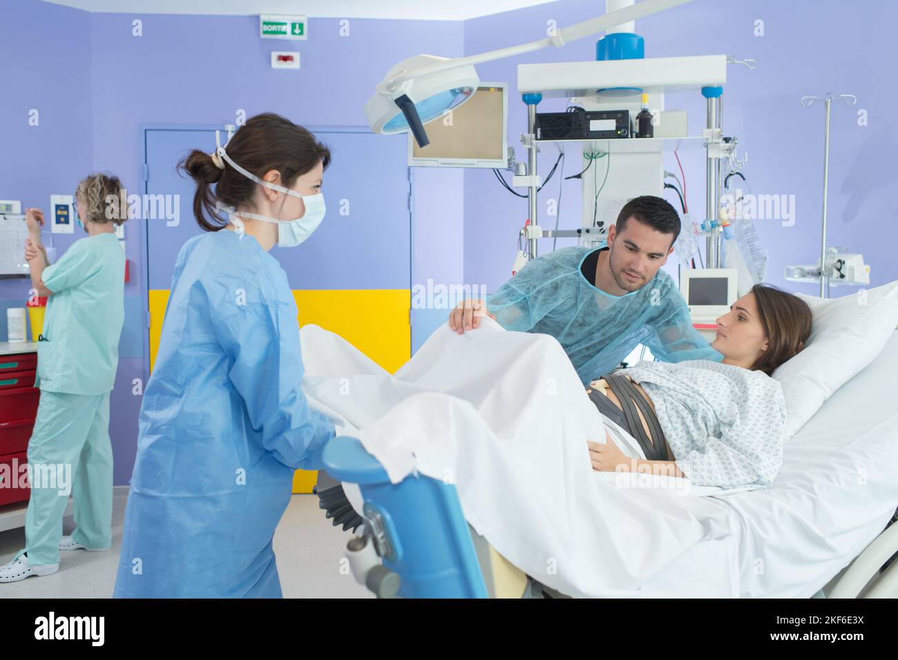 medical team husband looking at woman during delivery in operating-room ...