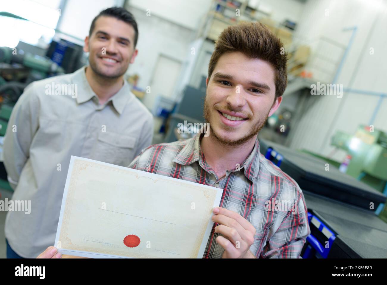 portrait of apprentice holding certificate Stock Photo - Alamy