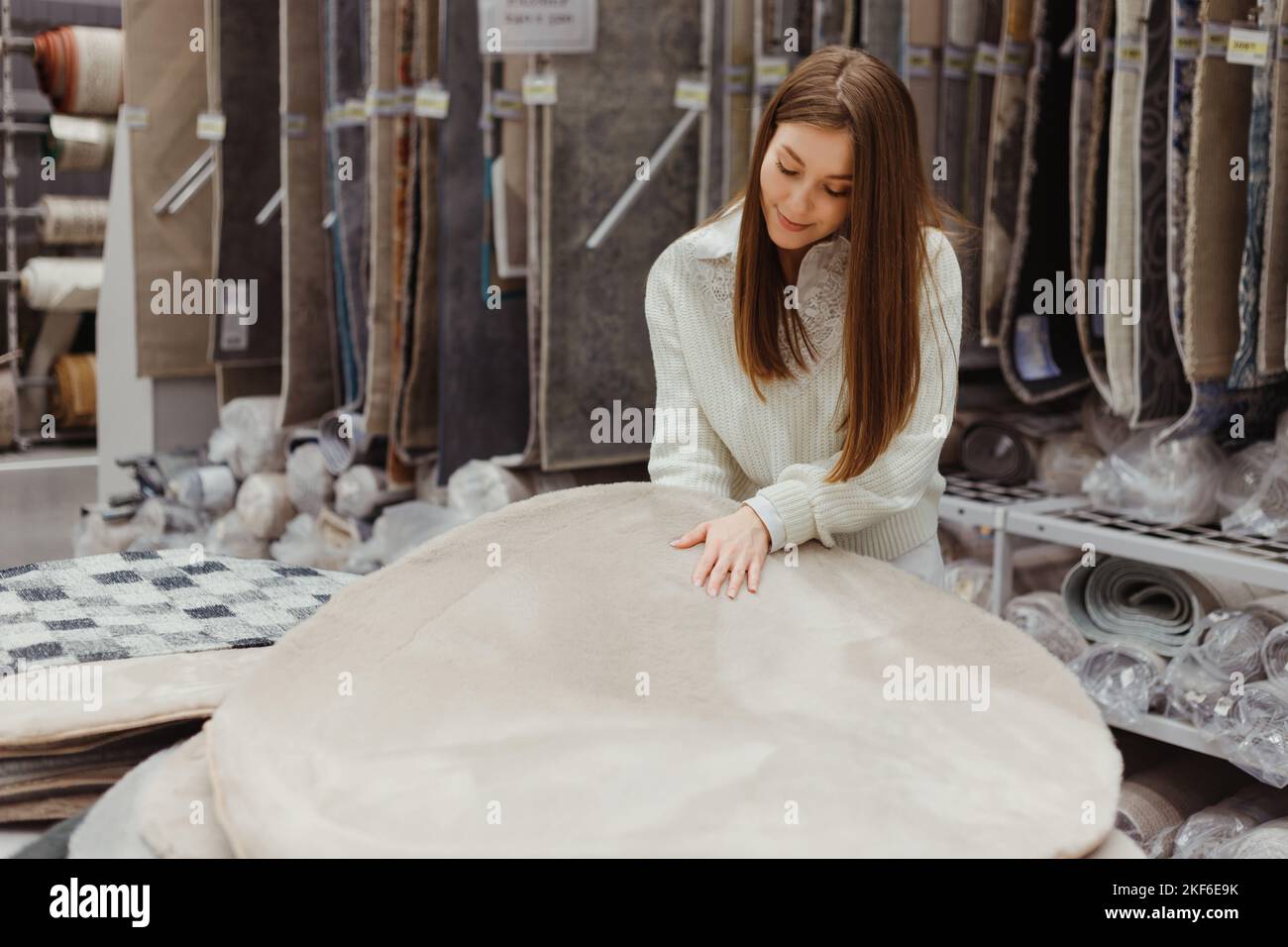 Woman touching soft fluffy carpet in hardware store, home furniture ...