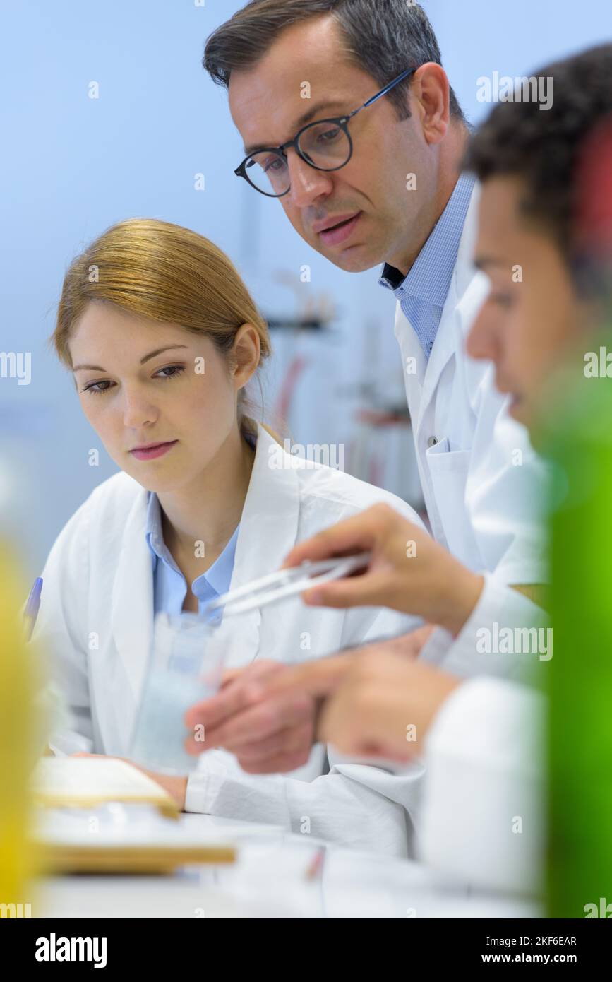 teacher watching over a science class experiment Stock Photo - Alamy