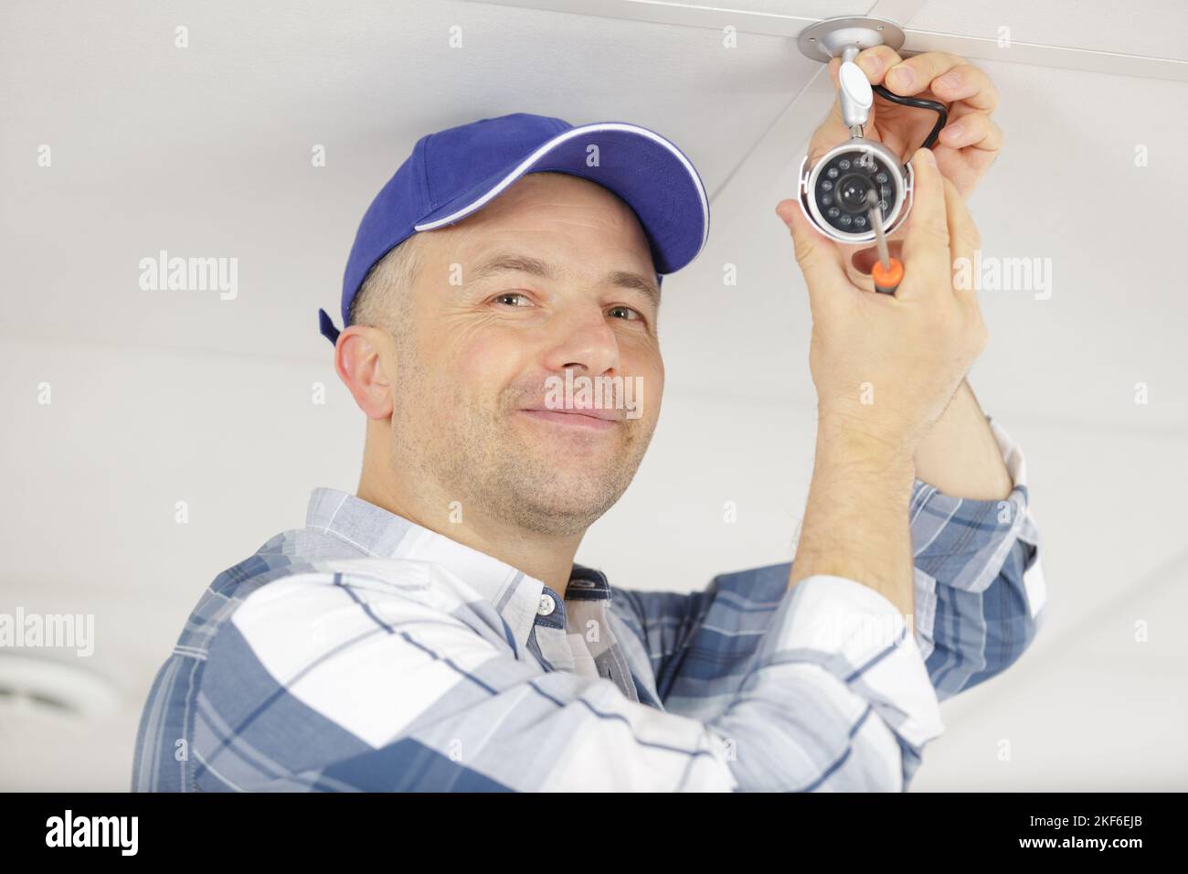 electrician connecting cctv camera in office Stock Photo - Alamy