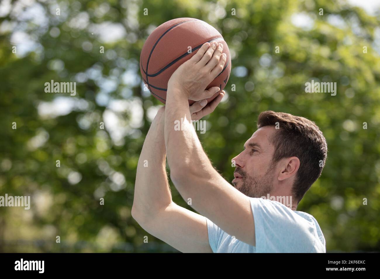 basketball player makes a throw on outdoor court Stock Photo - Alamy