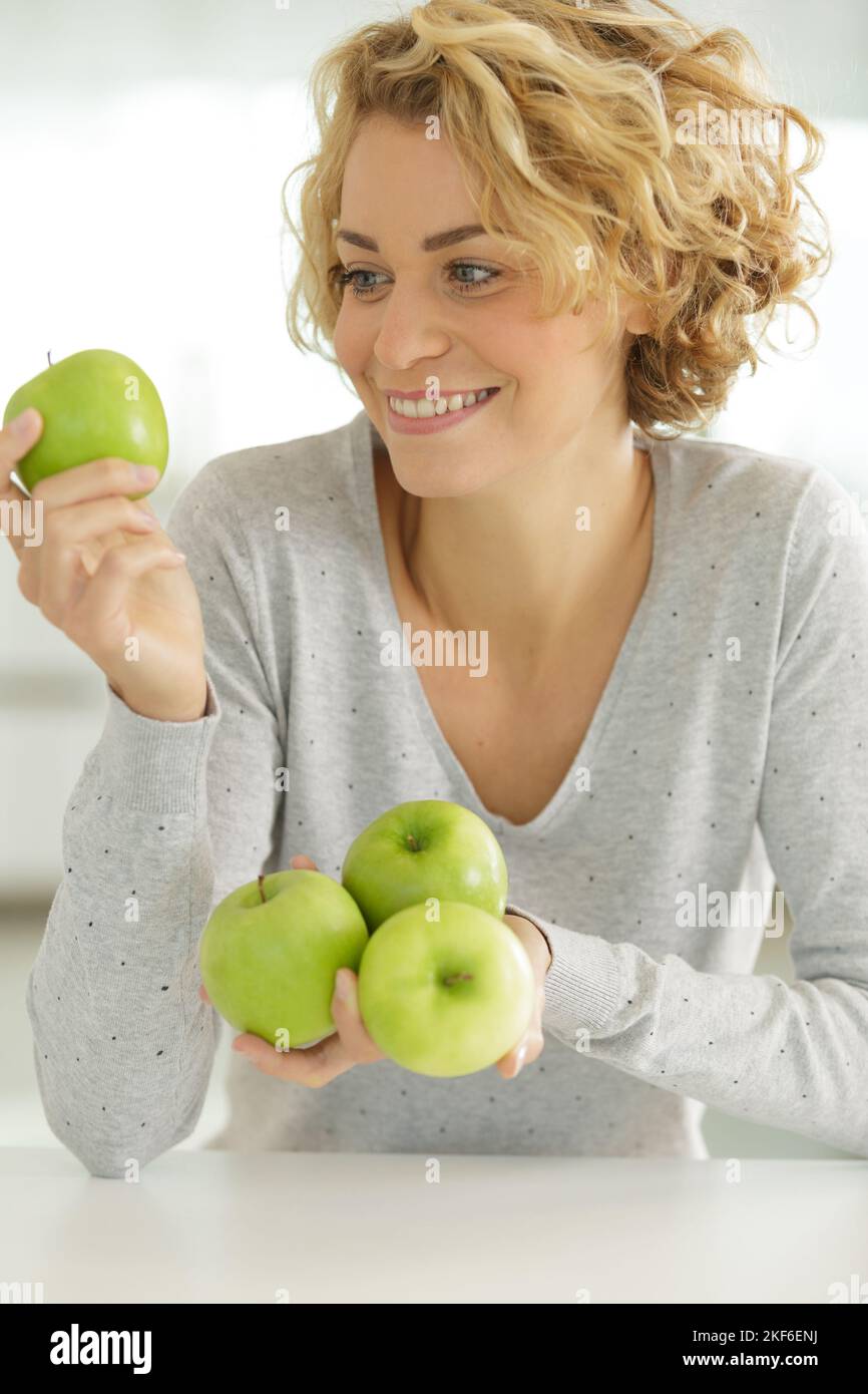 smiling young woman holding apple Stock Photo - Alamy