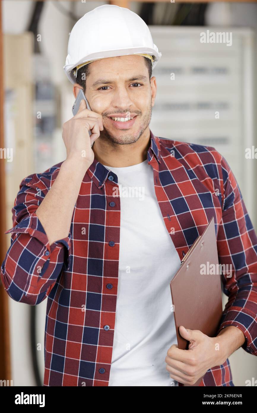 worker talking on the phone holding clipboard Stock Photo - Alamy