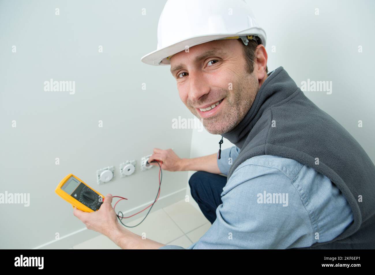 electrician checking socket voltage using multimeter Stock Photo - Alamy