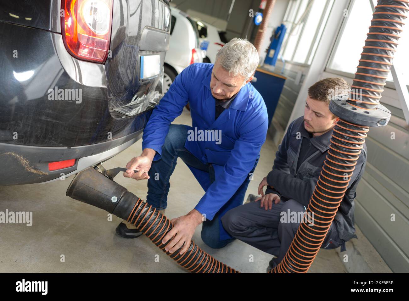 student with instructor repairing a car during apprenticeship Stock ...