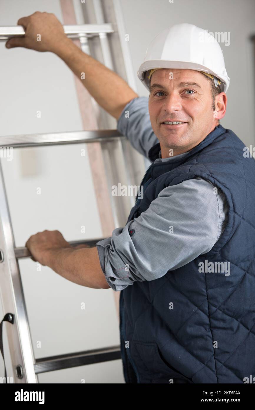 middle aged builder on a ladder Stock Photo - Alamy