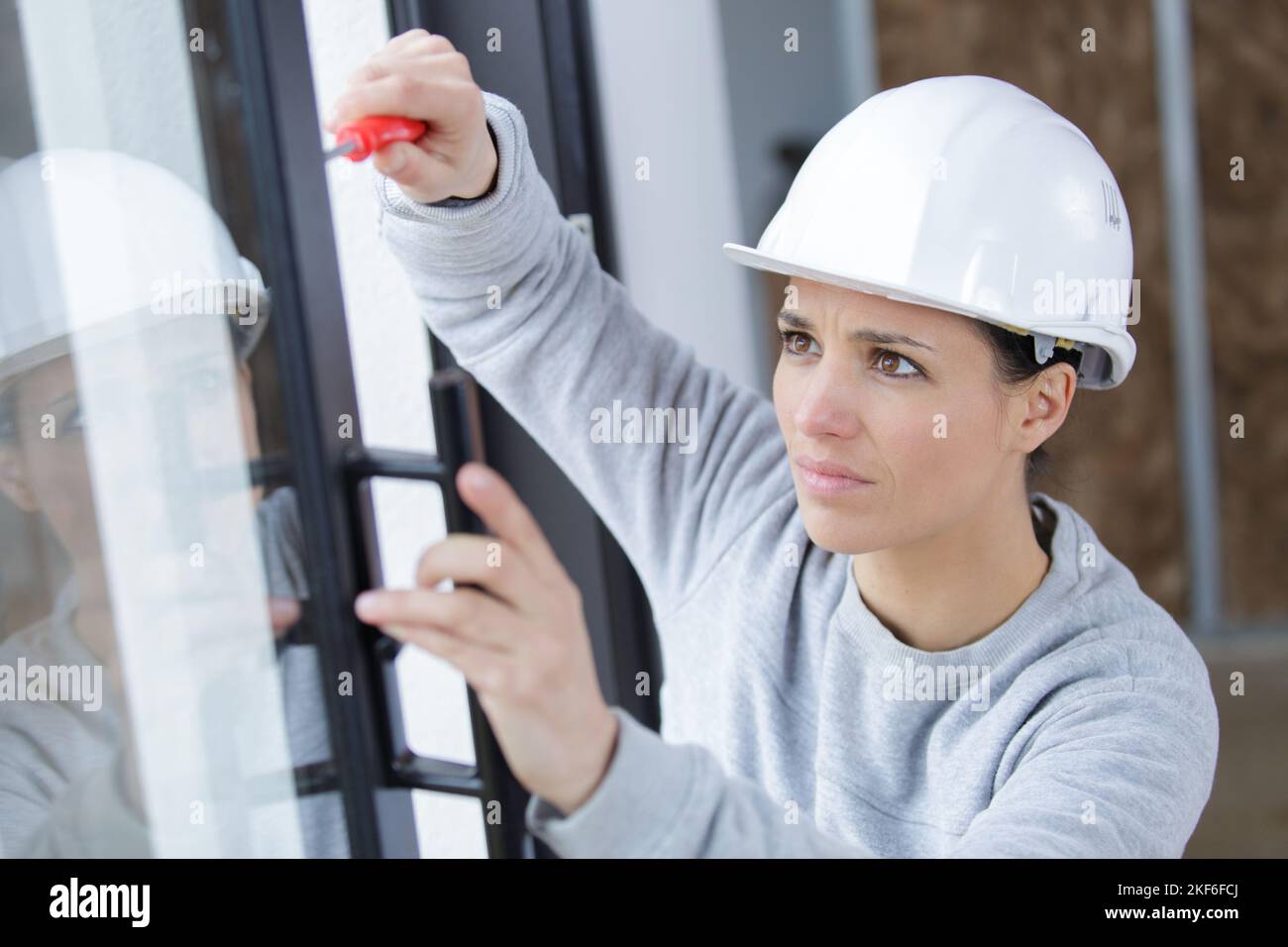 female worker using screwdriver working on pvc window frame Stock Photo ...