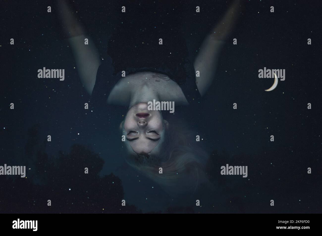 Young woman floating in water that reflects a starry night sky and the ...