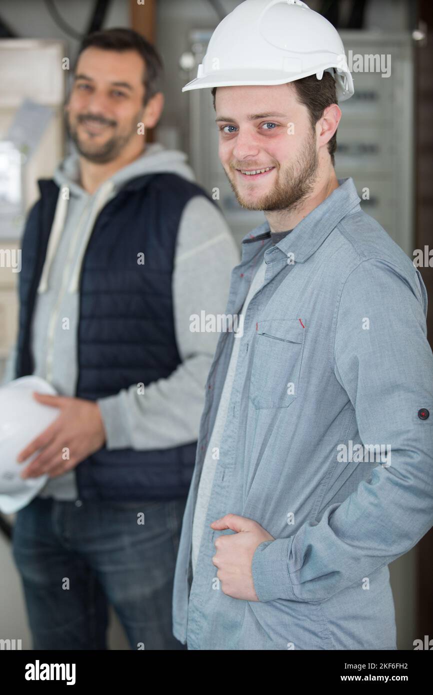two builders in work clothes smiling at the camera Stock Photo - Alamy