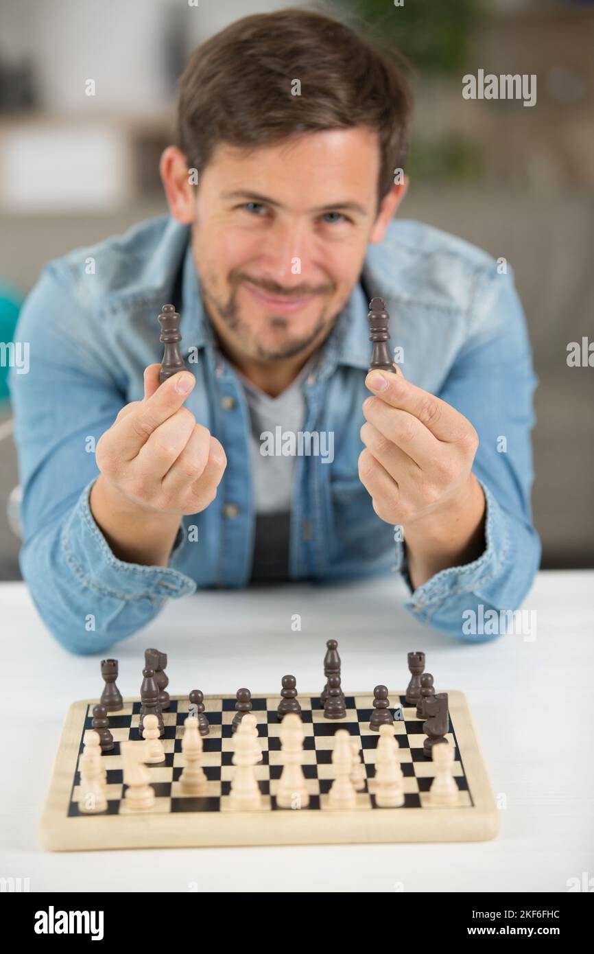 young man holding chess pieces Stock Photo - Alamy