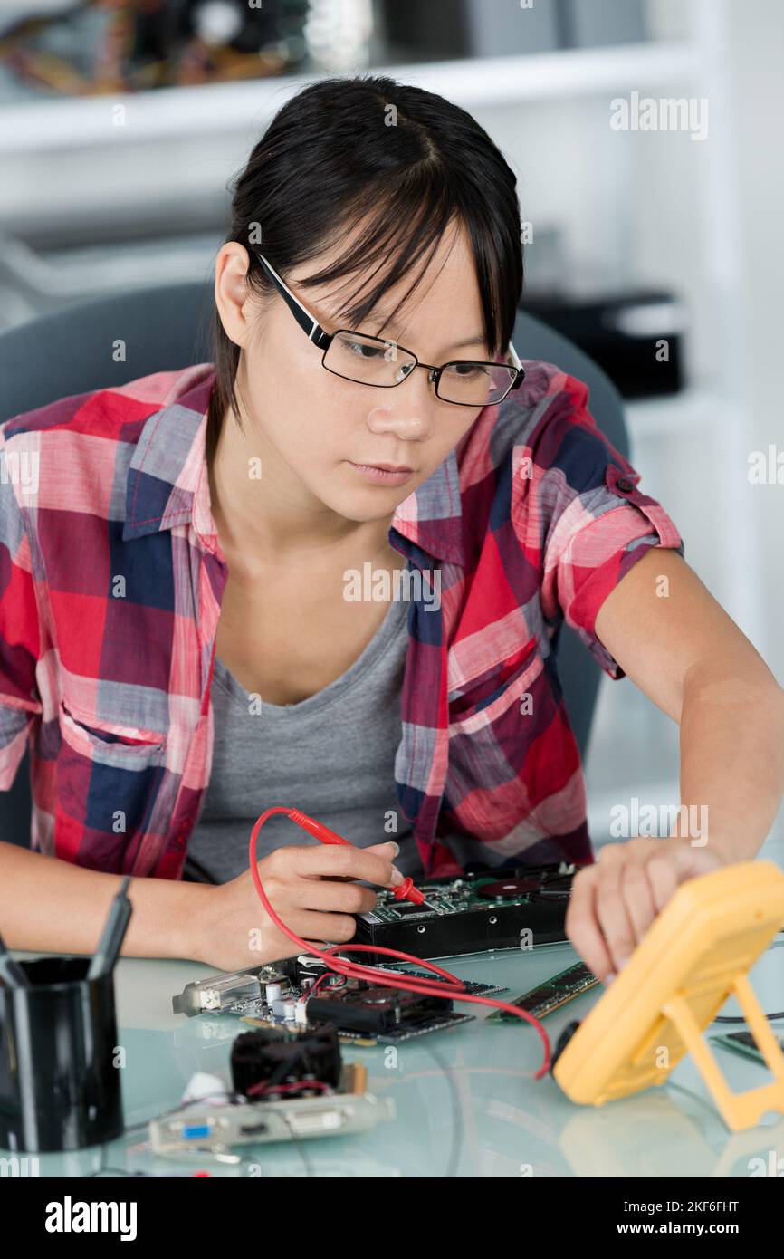 female technician using multimeter for voltage pc measurement Stock ...