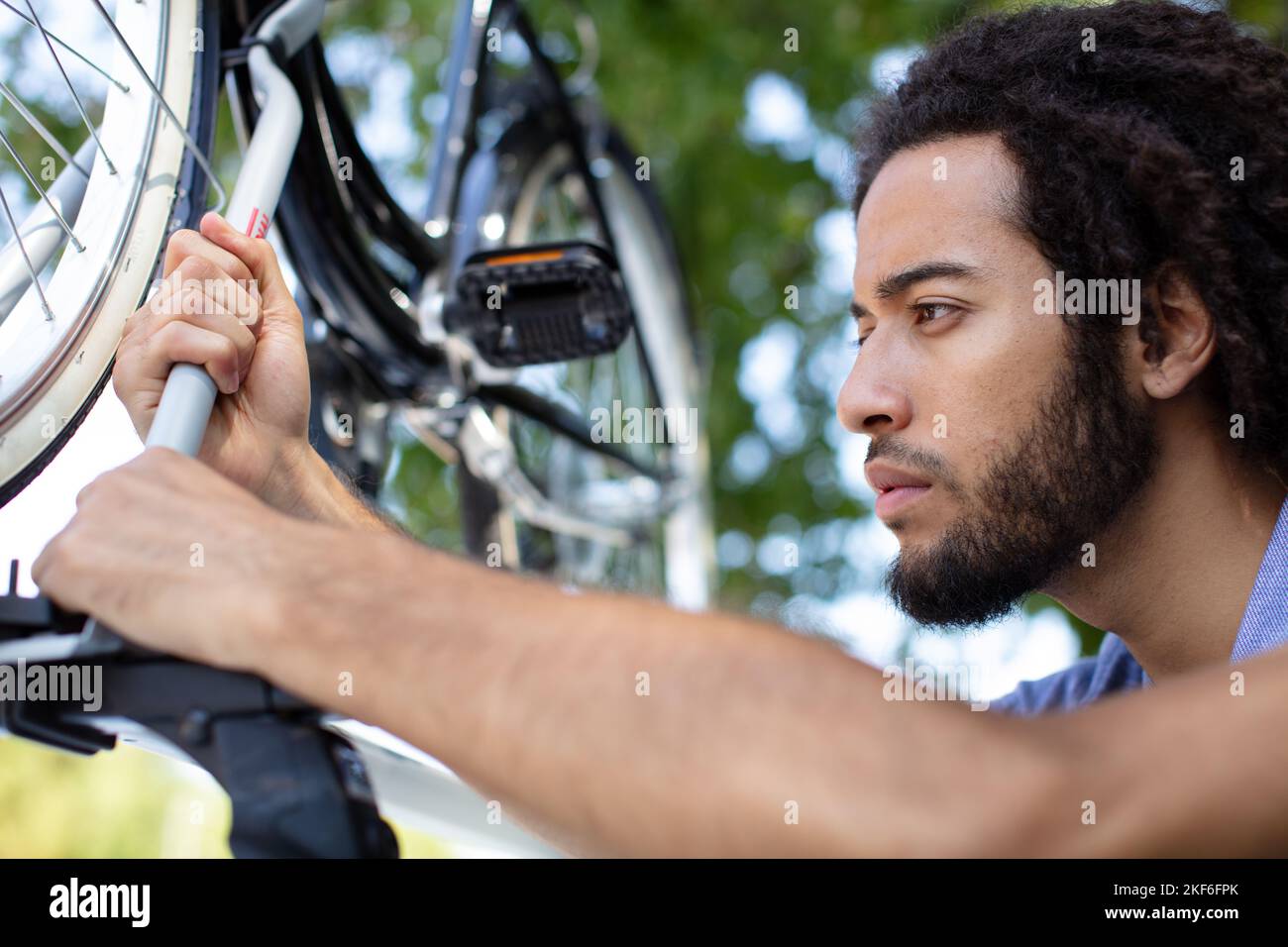 man takes off his bike from the car roof Stock Photo - Alamy