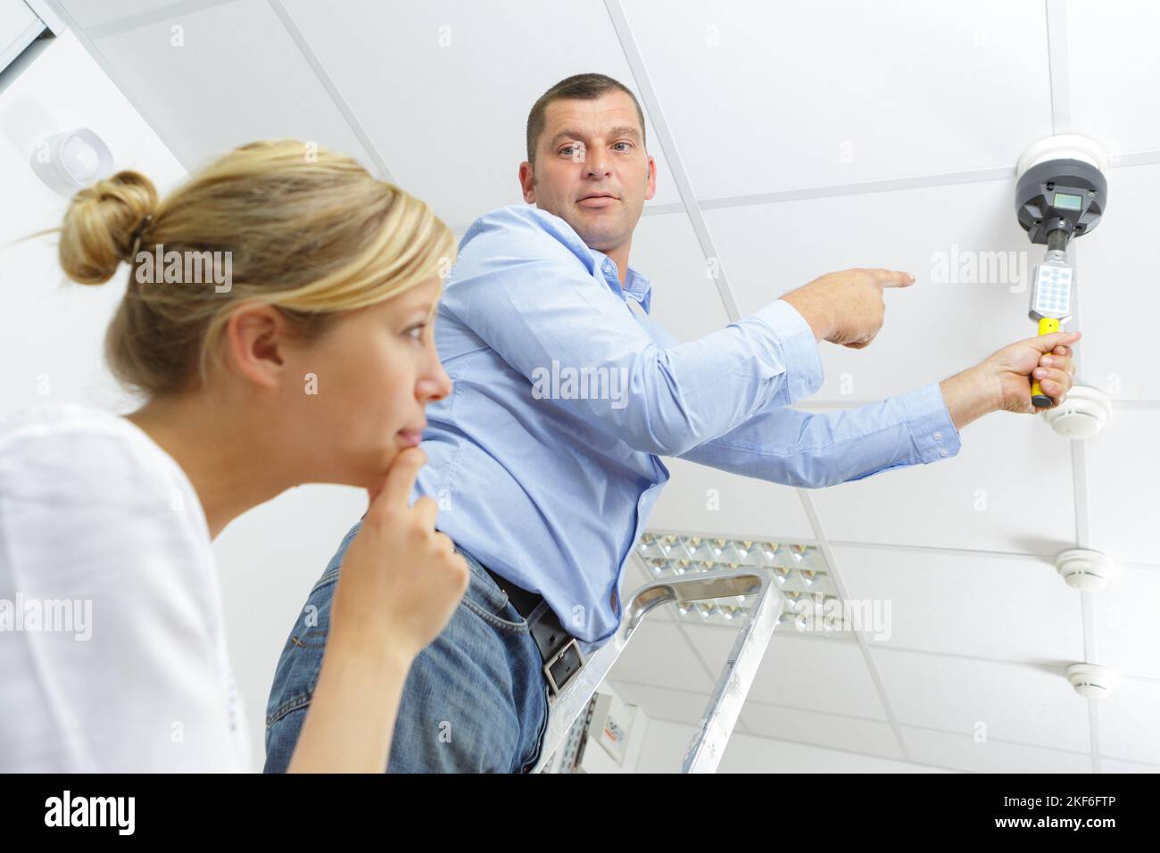fireman inspecting smoke detection device Stock Photo - Alamy