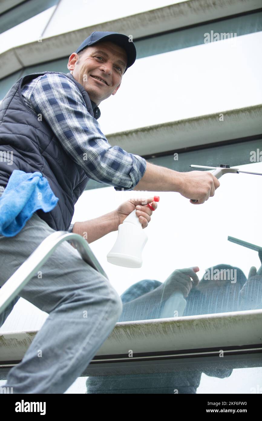 man on stepladder washing window outdoors Stock Photo - Alamy