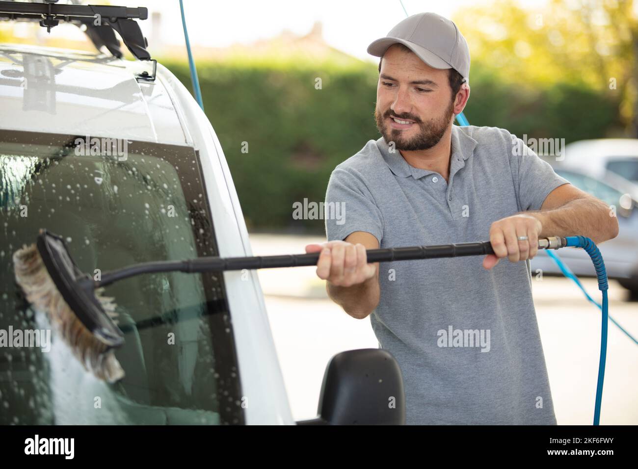 man worker washing car on a car wash Stock Photo - Alamy