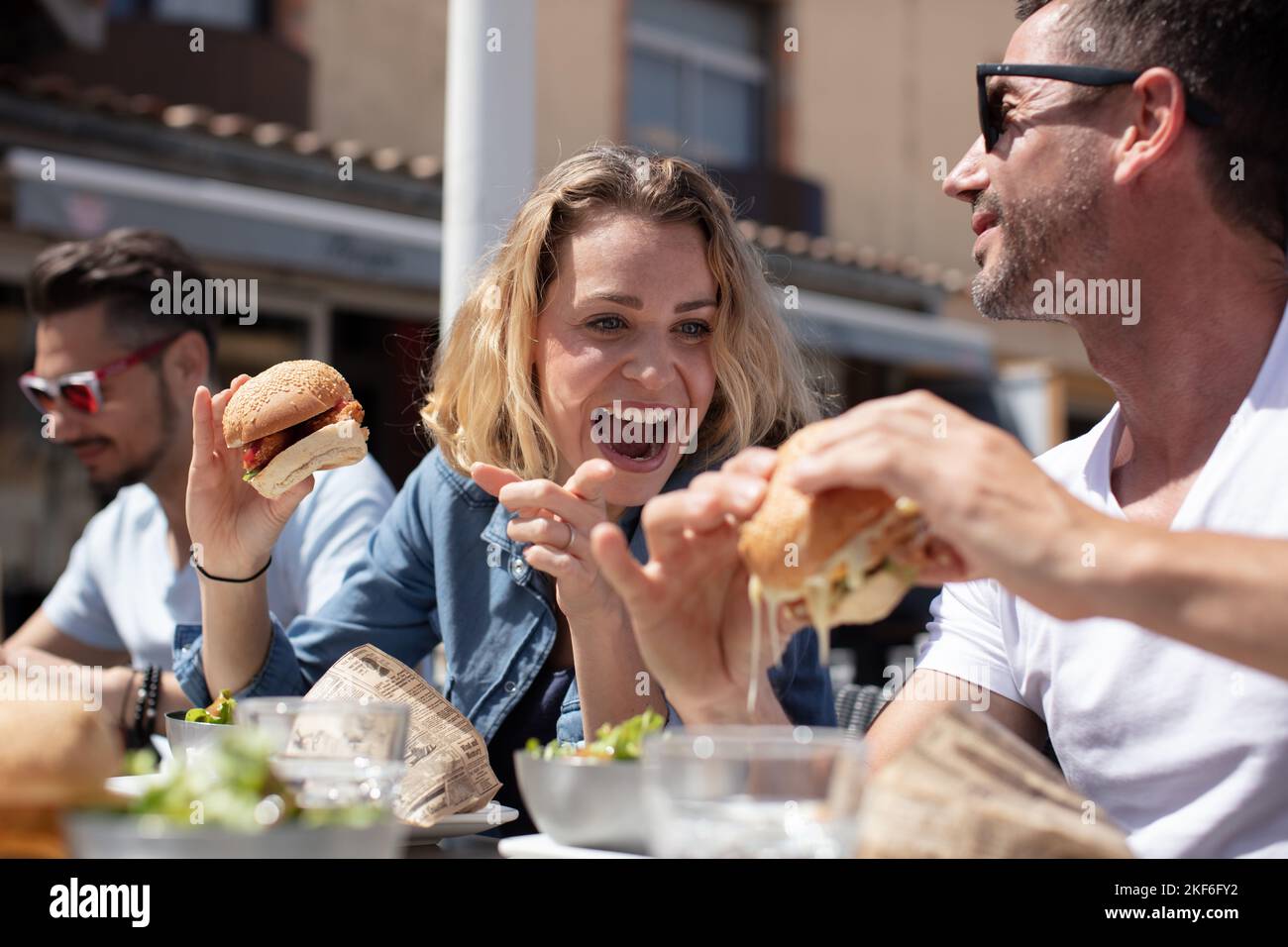 happy lovers eating big burgers outdoors Stock Photo - Alamy