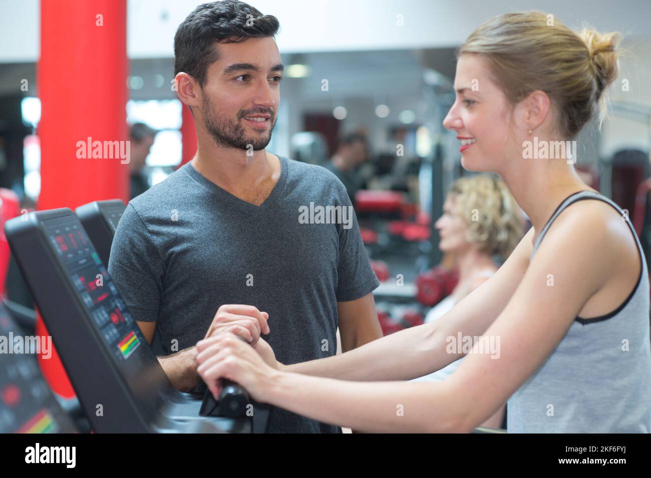 personal trainer helping woman in gym Stock Photo - Alamy