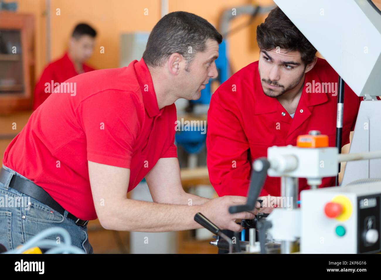 two men operating machines in factory Stock Photo - Alamy