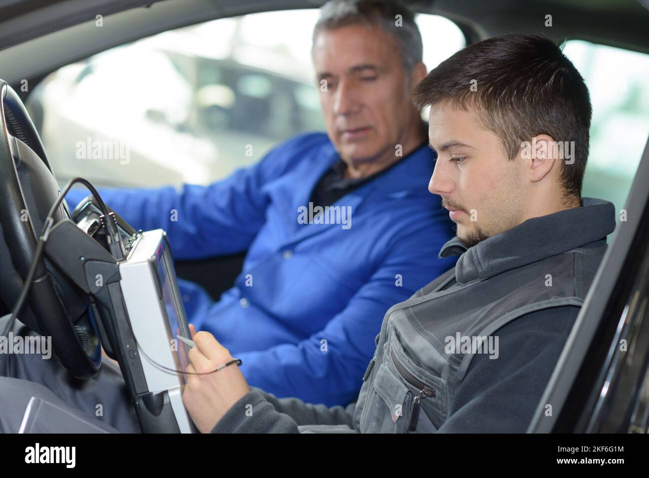 auto mechanic teacher and trainee performing tests at mechanic school ...