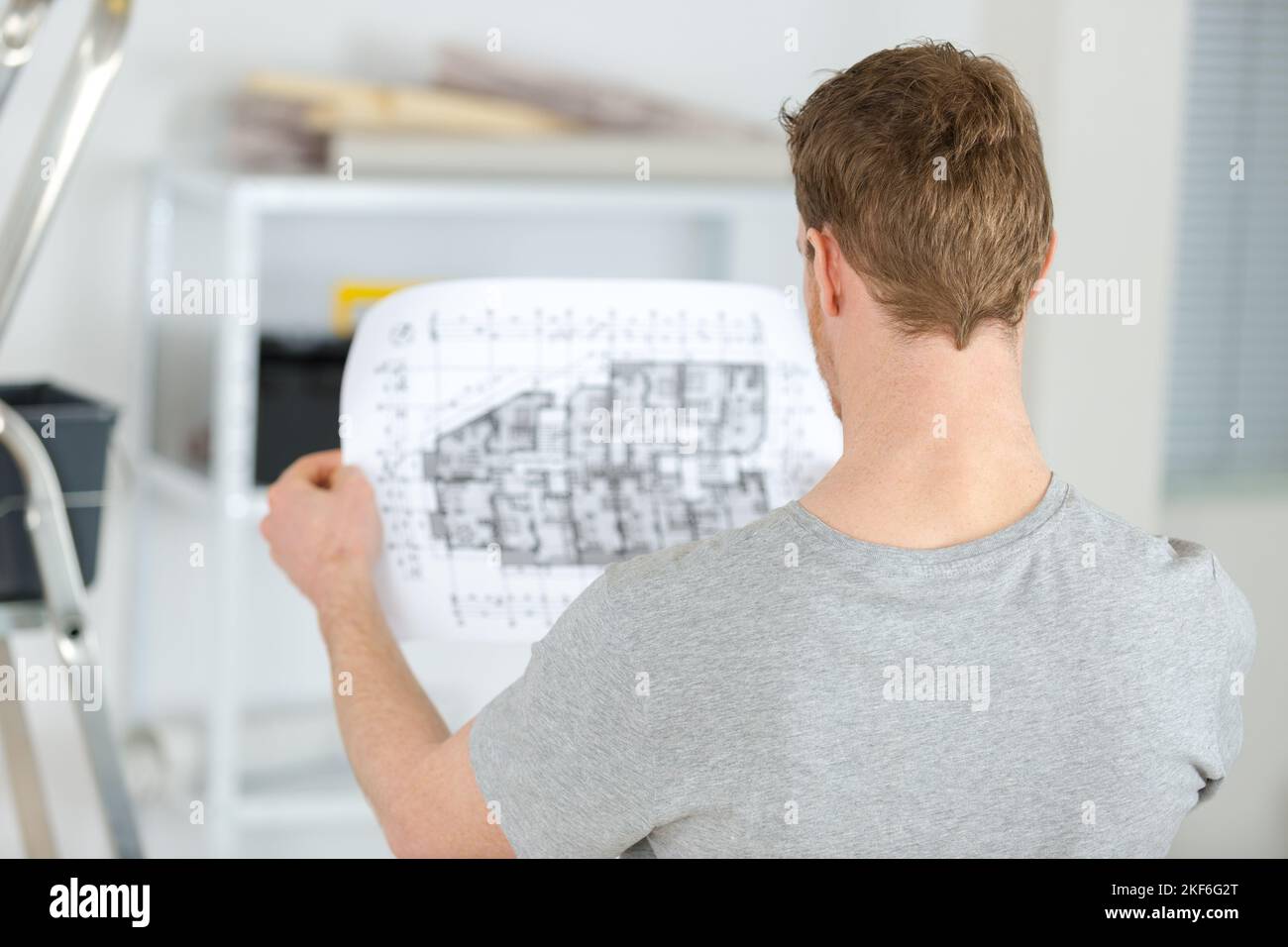 man in room looking at blueprints Stock Photo - Alamy