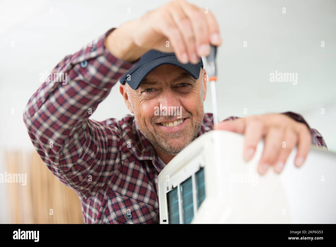 male air conditioning technician smiling at the camera Stock Photo - Alamy