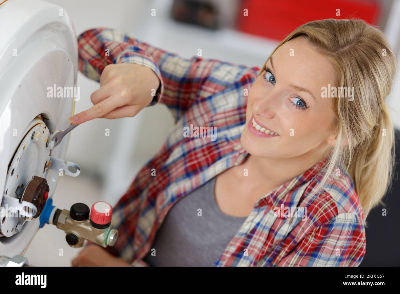attractive female working on water heater Stock Photo - Alamy