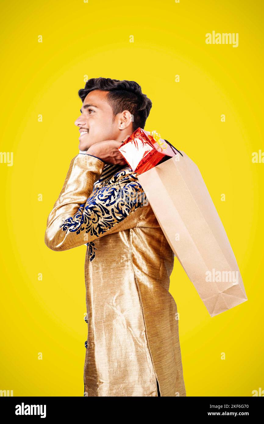 Indian man in ethnic wear with shopping bags and gift box, isolated ...