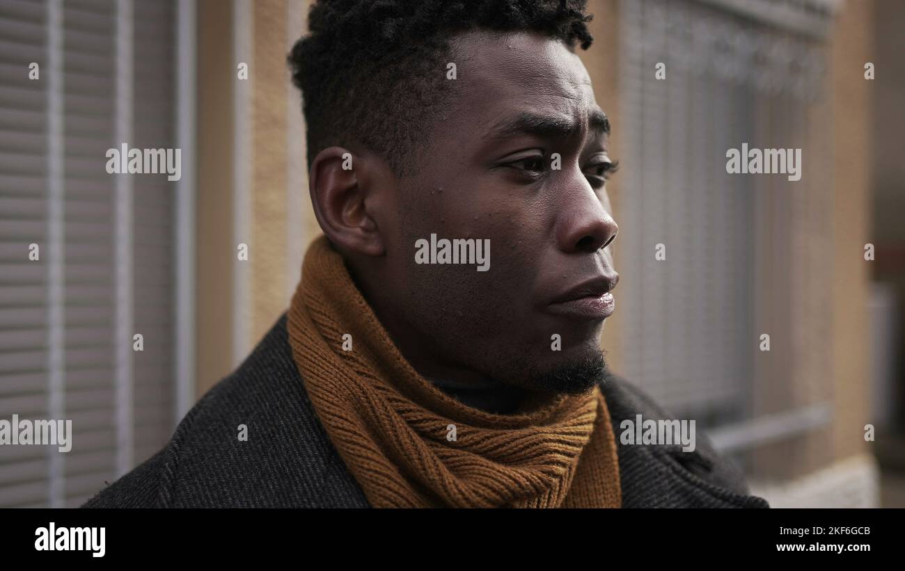 Concerned black man standing outside in city, close-up face portrait ...