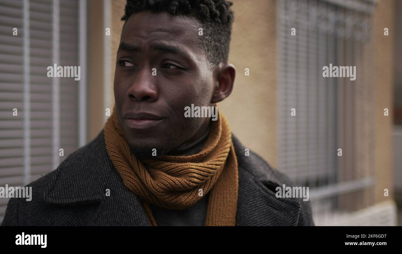 Concerned black man standing outside in city, close-up face portrait ...