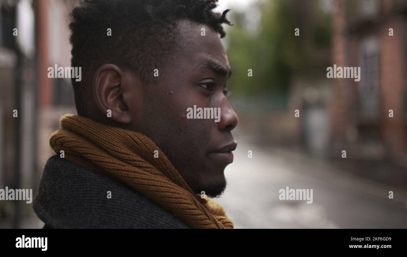 Concerned black man standing outside in city, close-up face portrait ...