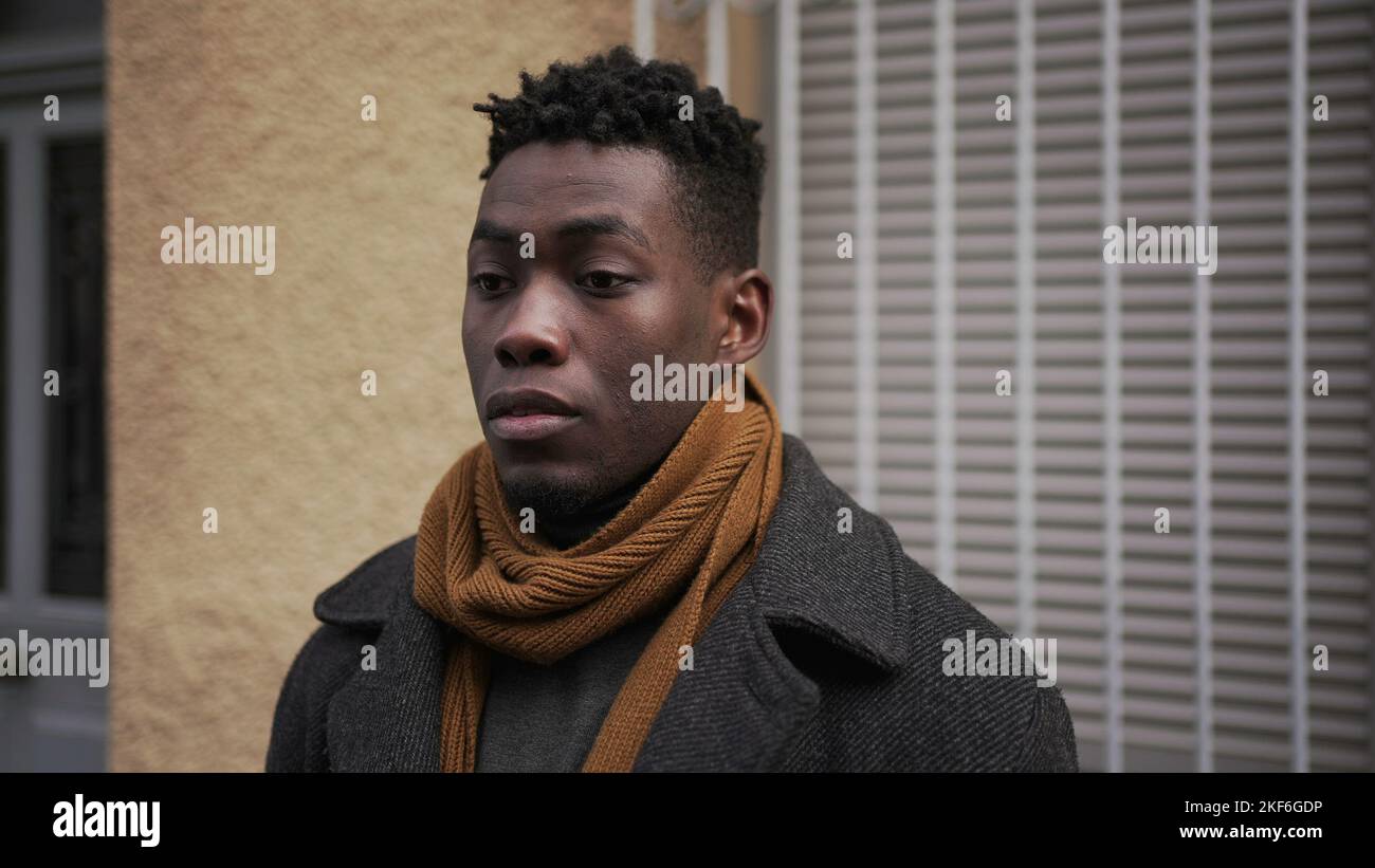 Concerned black man standing outside in city, close-up face portrait ...