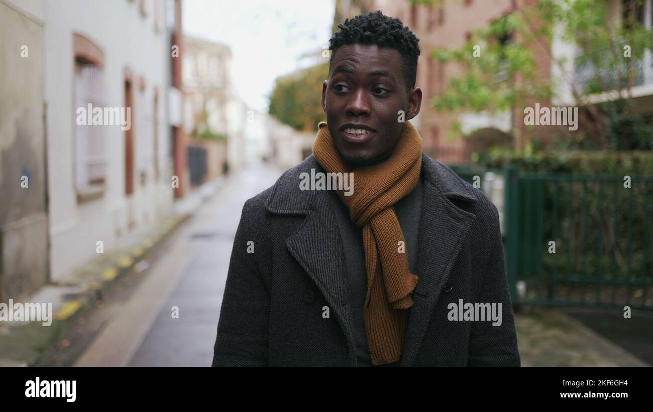 Confident elegant black African walks forward smiling during winter in ...