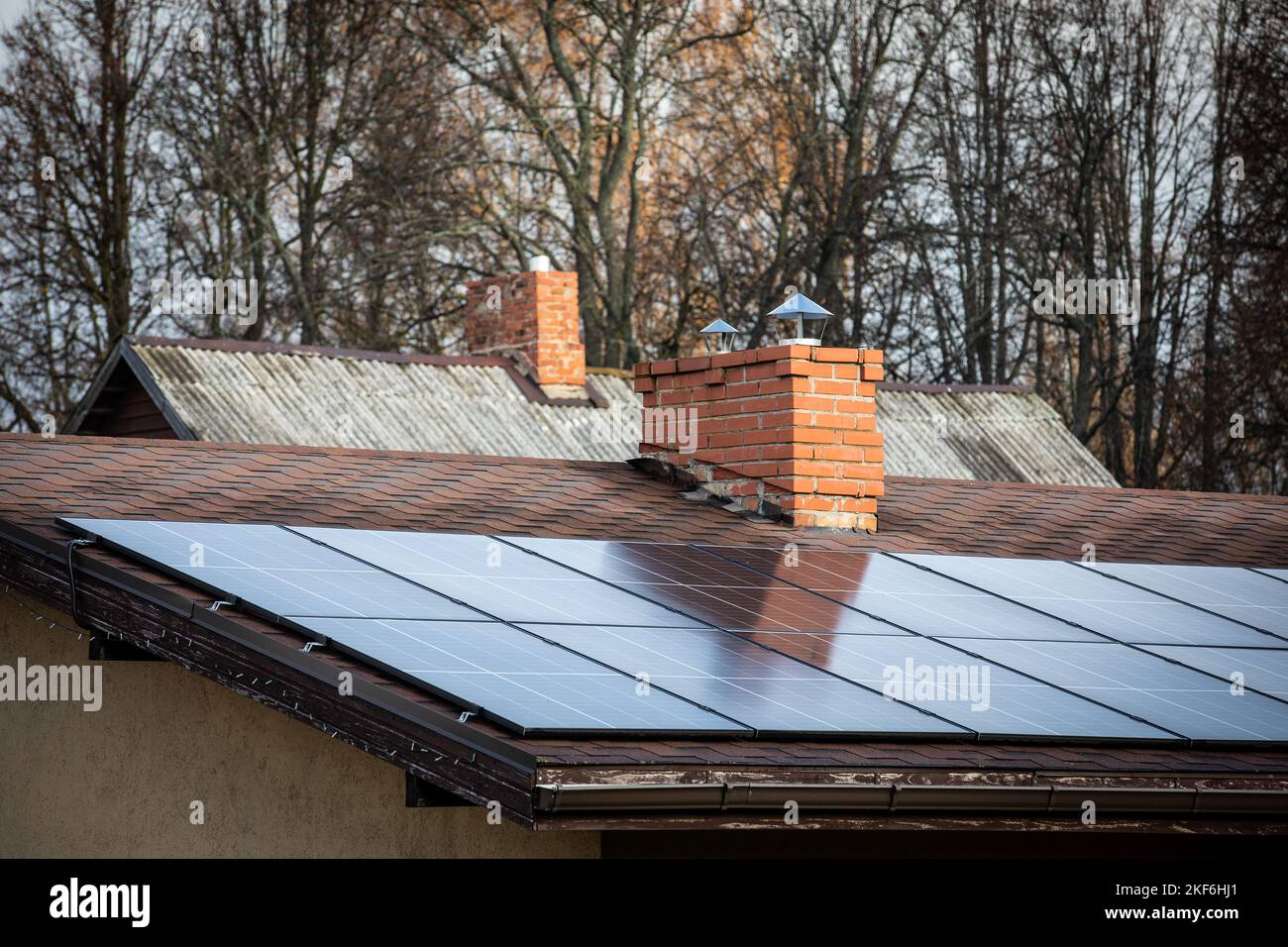 Solar panels on a shingle roof. Brick chimneys Stock Photo - Alamy