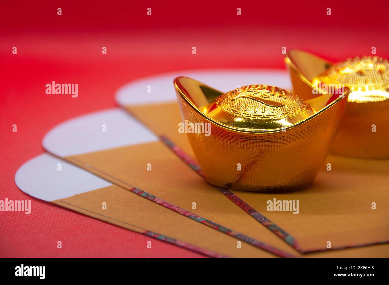 Close up on gold ingots on yellow packets. Chinese New Year celebration ...