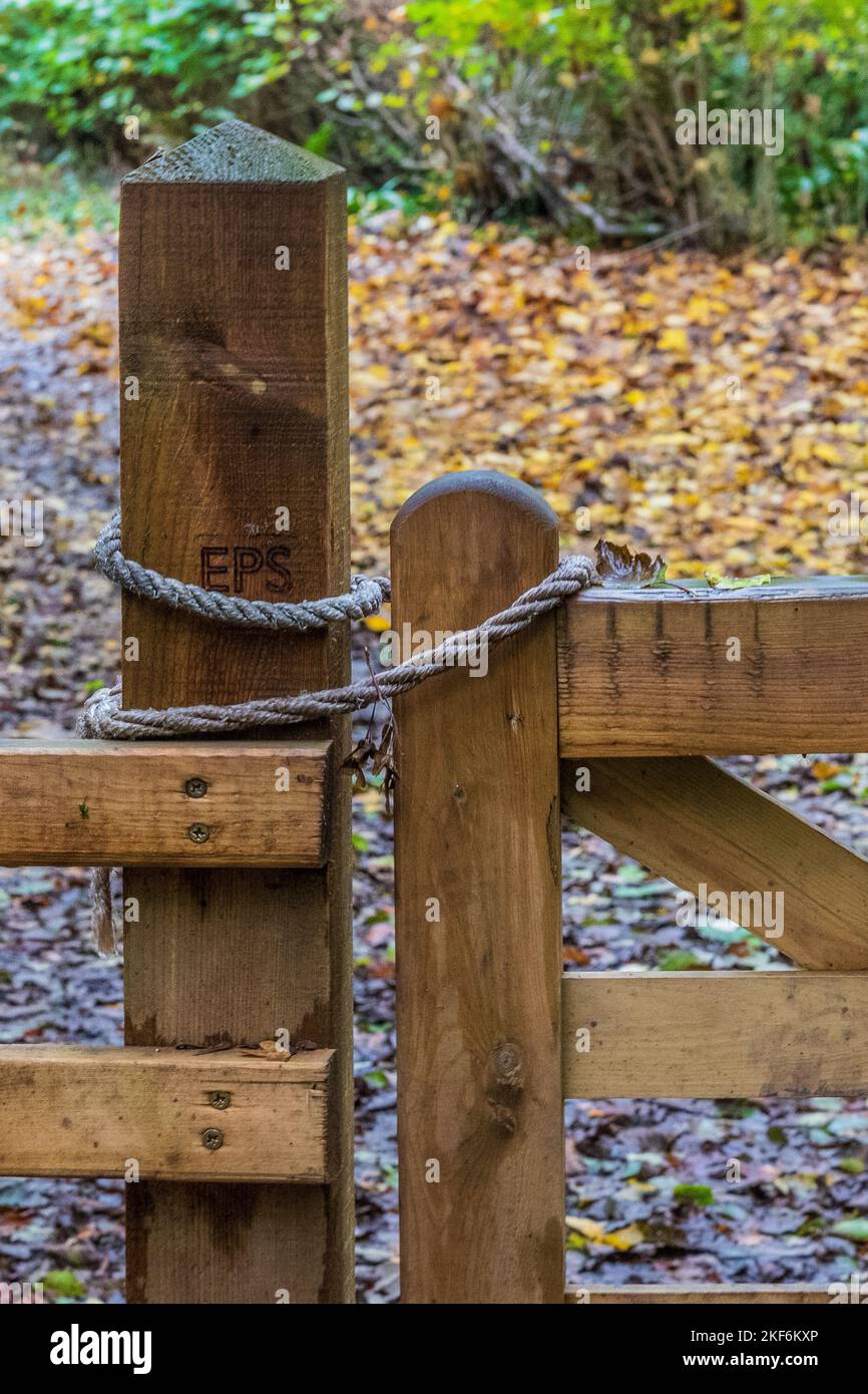 A new wooden gate kept closed with rope at a nature reserve. Concept ...