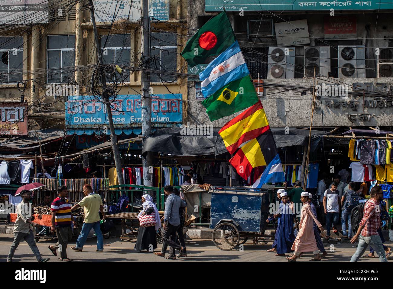 Residents walk past a vendor selling national flags of participating ...