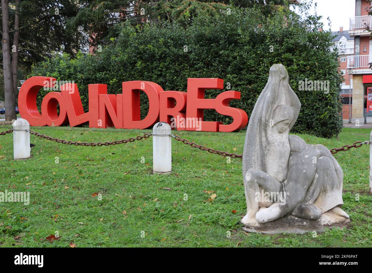 Colindres named in large red letters in a park with a stone sculpture ...