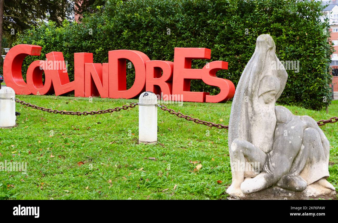 Colindres named in large red letters in a park with a stone sculpture ...